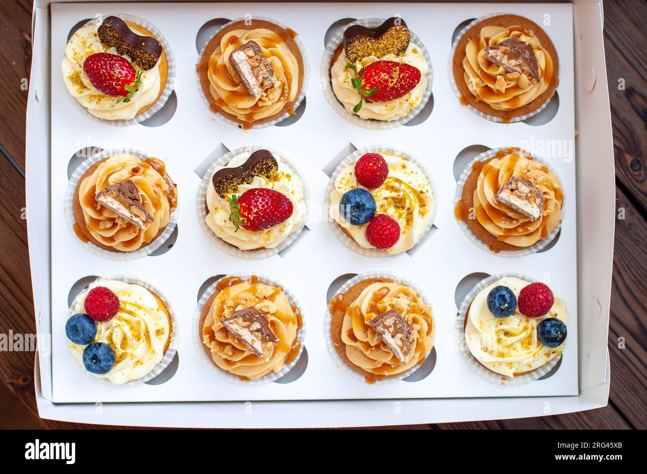 Assorted cupcakes in gift box with fresh strawberries, peanut butter ...