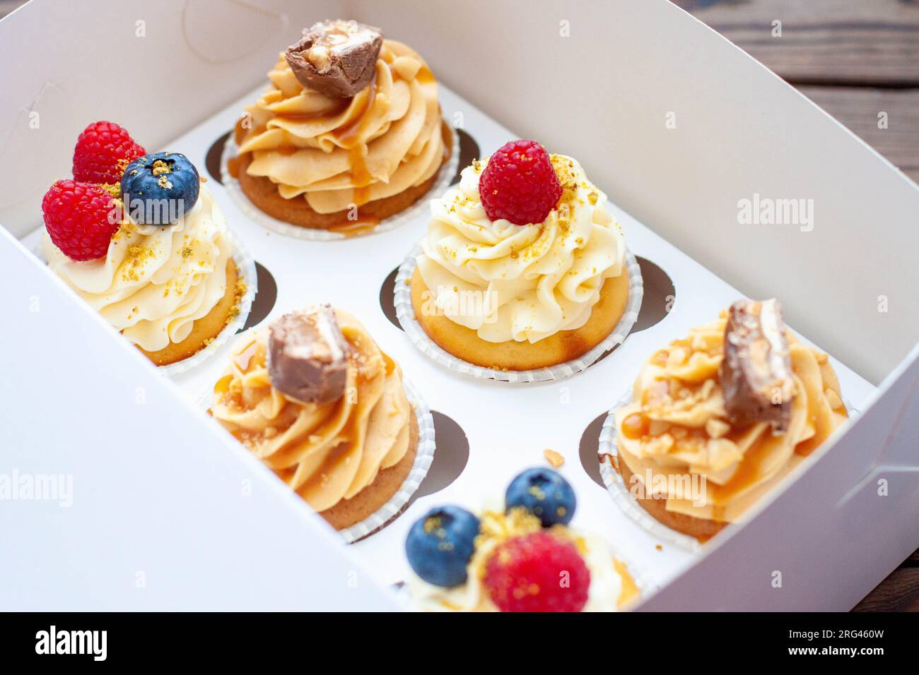 Assorted cupcakes in gift box with fresh strawberries, peanut butter ...