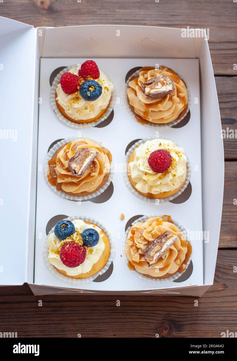 Assorted cupcakes in gift box with fresh strawberries, peanut butter ...