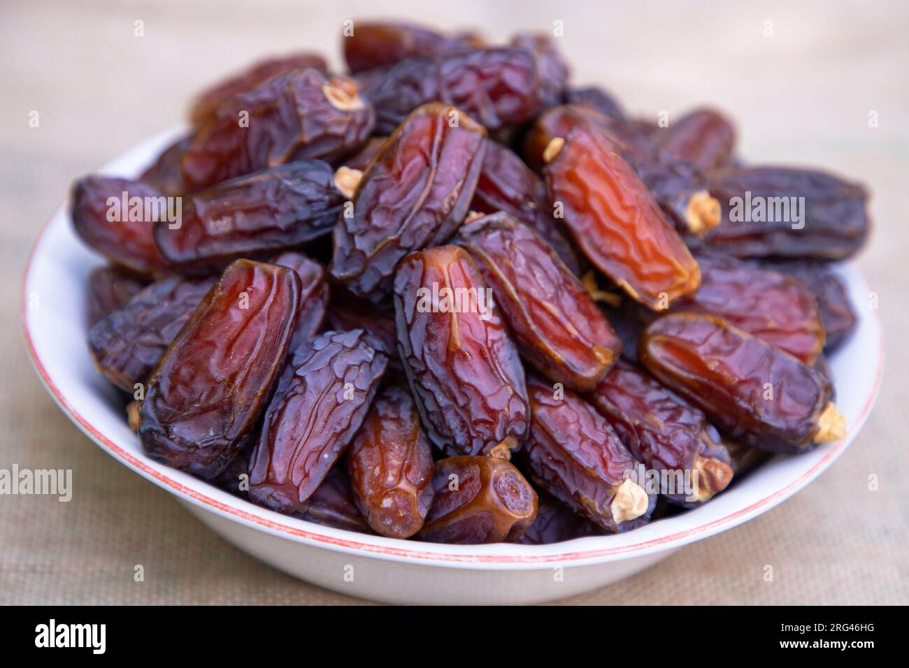 One bowl delicious Date fruits on the jute fiber fabric. Selective ...
