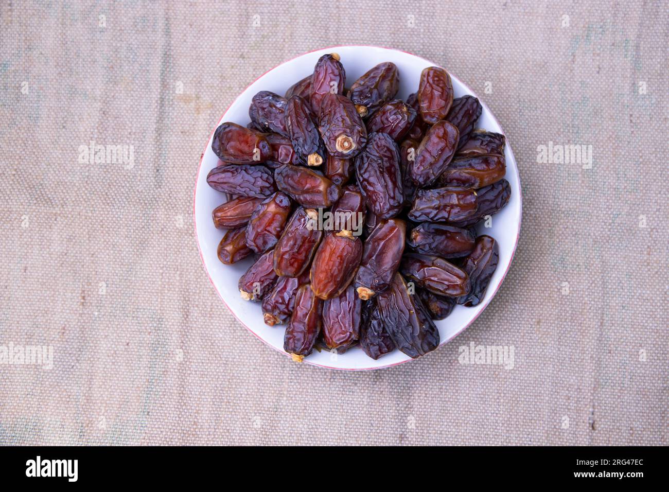 One Bowl delicious Date fruits on the brown jute fiber fabric to eat ...