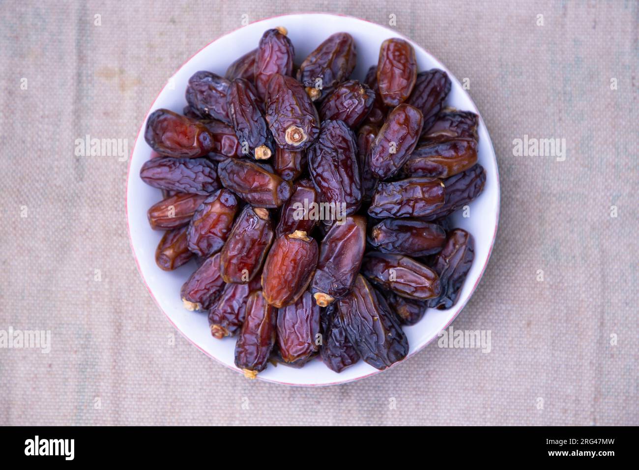 One Bowl delicious Date fruits on the brown jute fiber fabric to eat ...