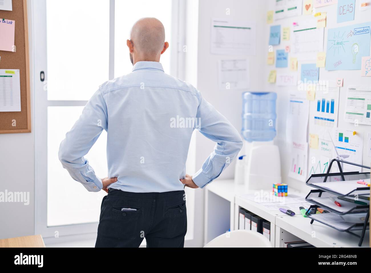 Young bald man business worker looking throw the window at office Stock ...