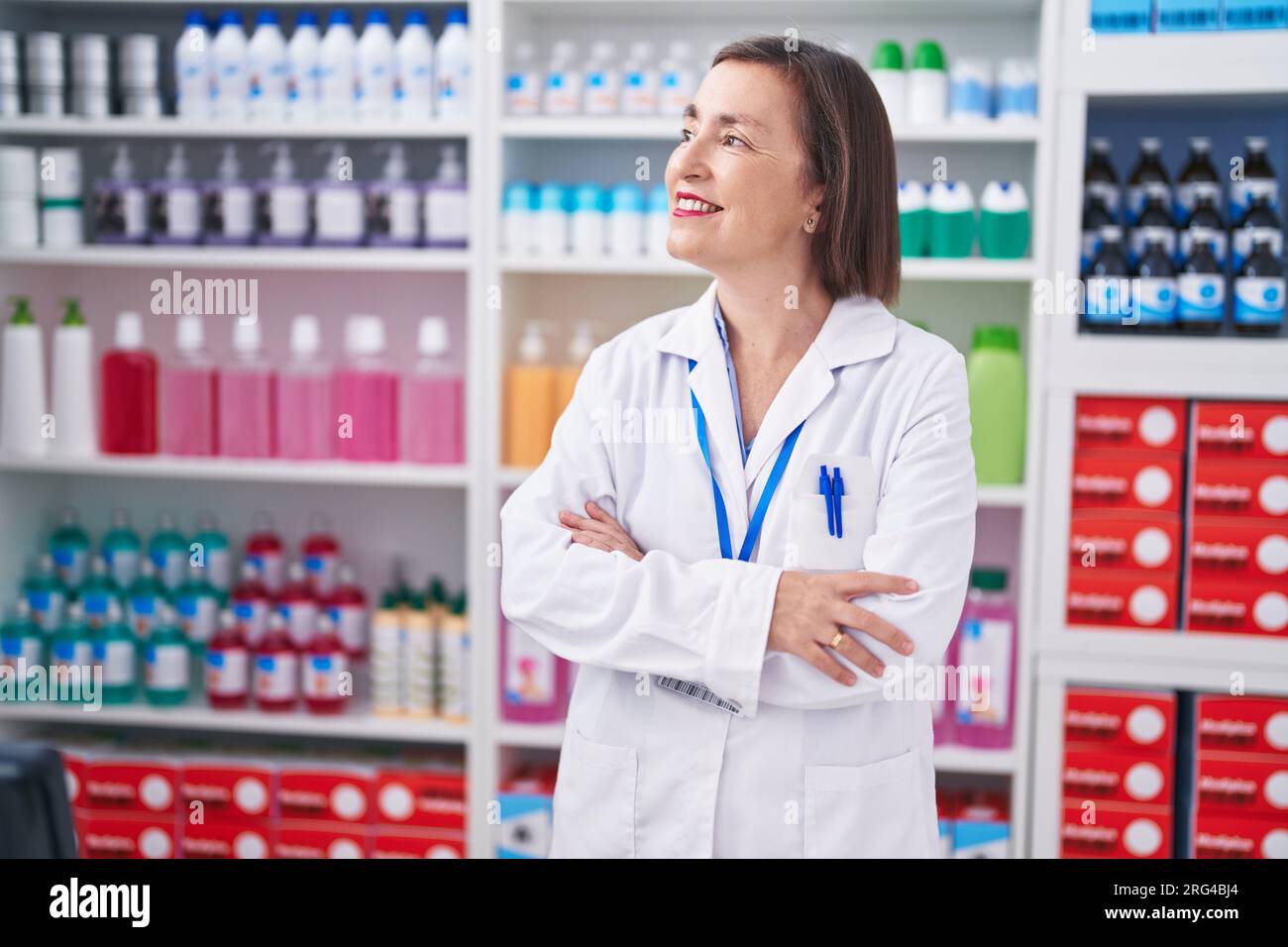 Middle age woman pharmacist smiling confident standing with arms ...