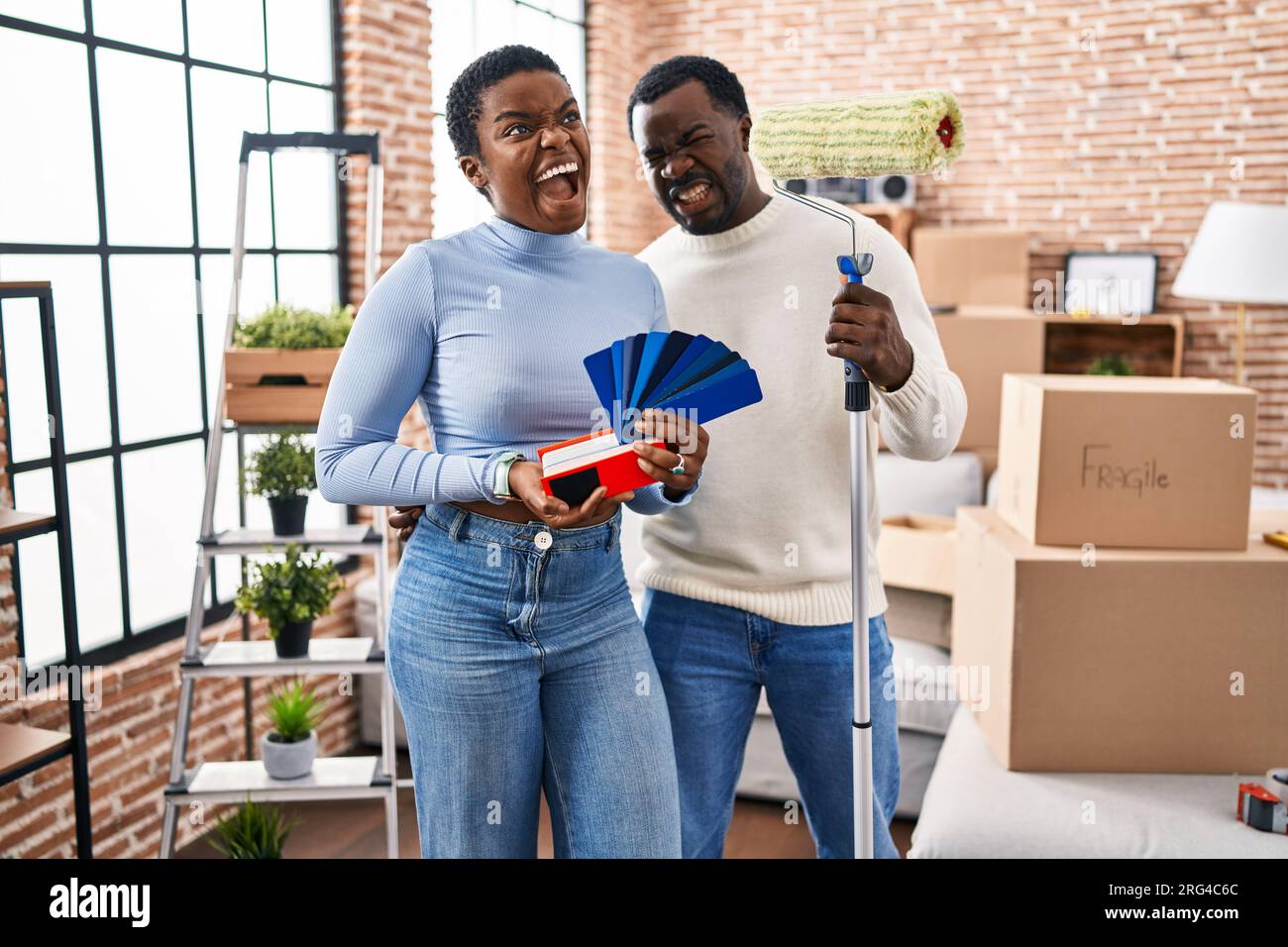 Young african american couple moving to a new home choosing walls color ...