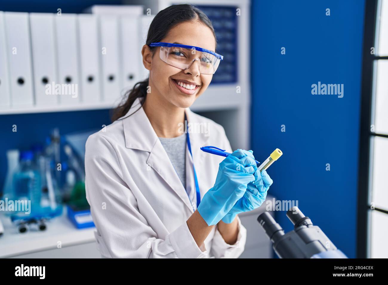 Young african american woman scientist write on test tube at laboratory ...