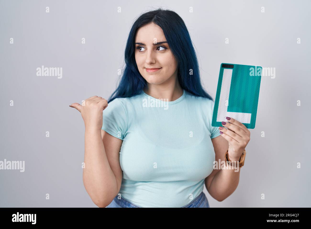 Young modern girl with blue hair holding l sign for new driver pointing ...