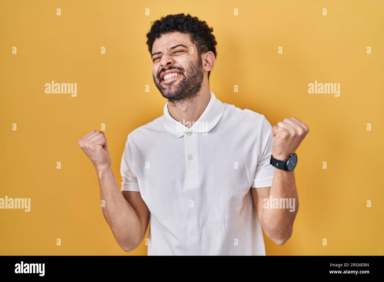 Arab man standing over yellow background celebrating surprised and ...
