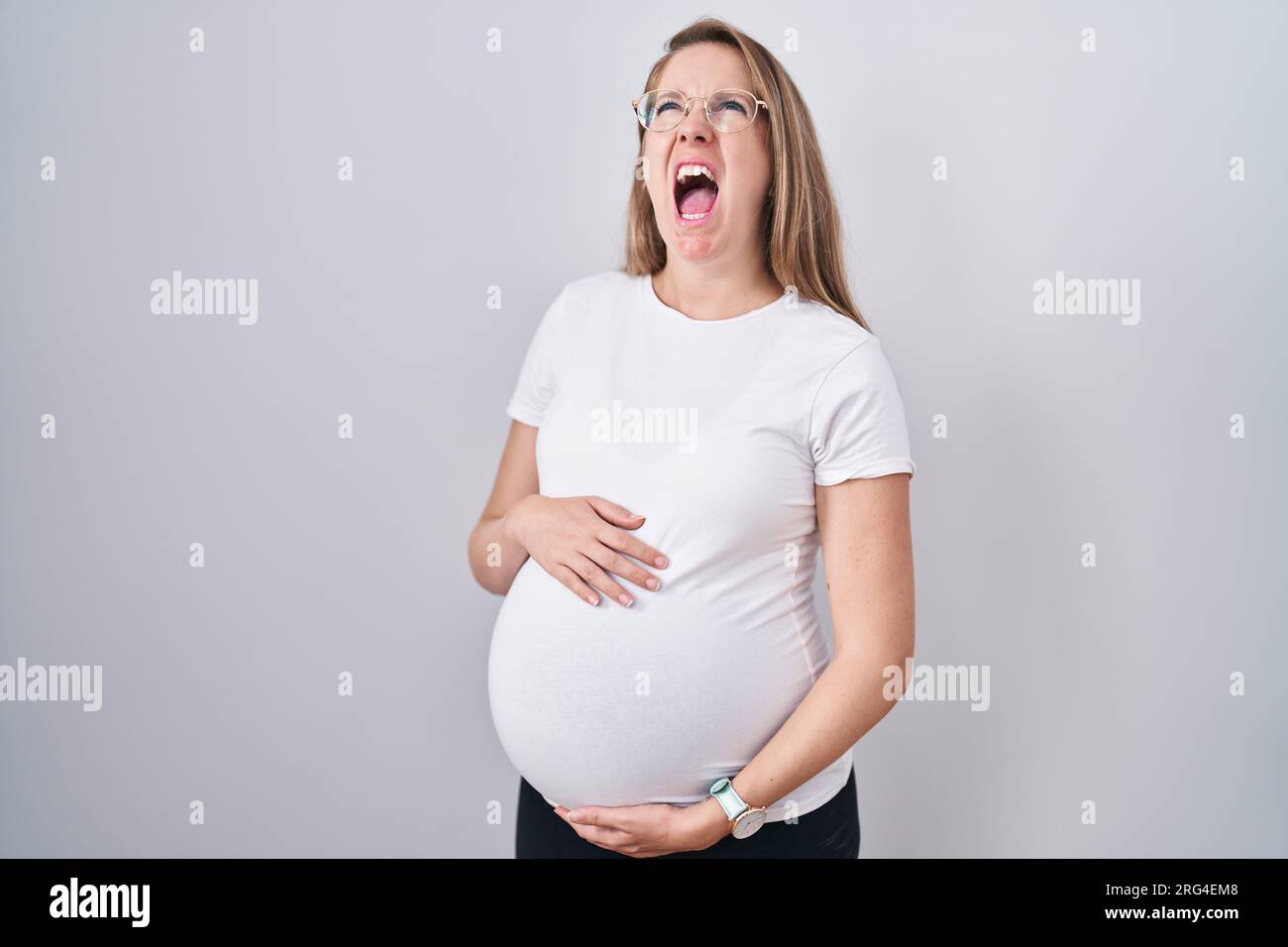 Young pregnant woman expecting a baby, touching pregnant belly angry ...