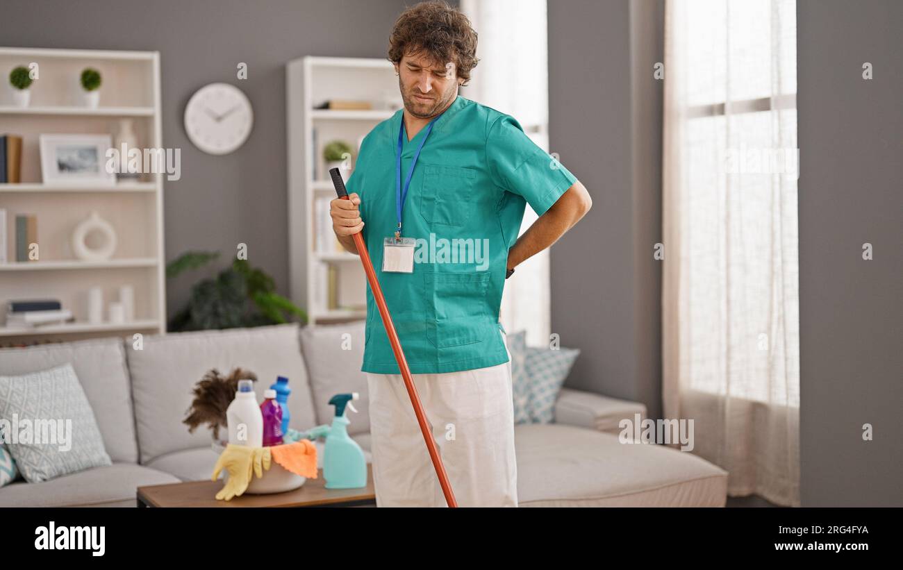 Young hispanic man professional cleaner cleaning floor suffering for ...