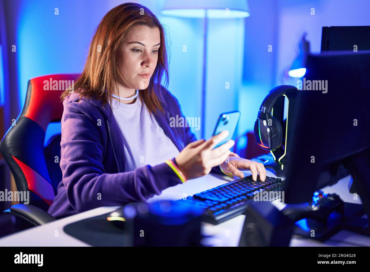 Young beautiful plus size woman streamer using computer and smartphone ...