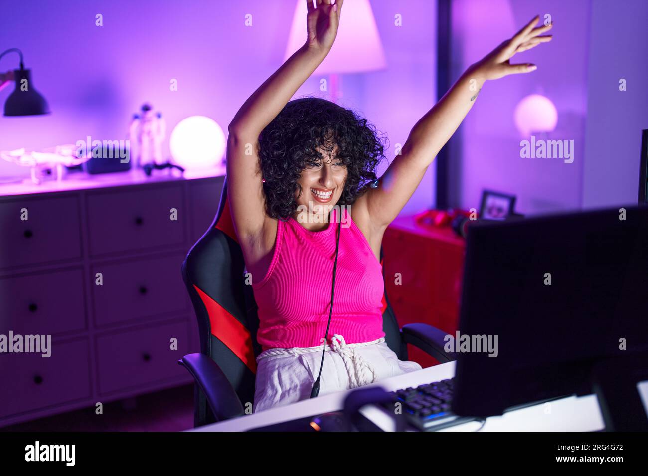 Young middle eastern woman streamer playing video game dancing at ...