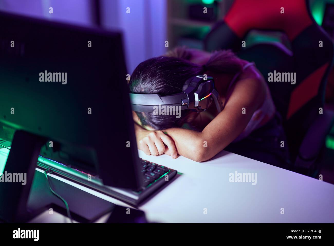 Young hispanic woman streamer stressed using computer at gaming room ...