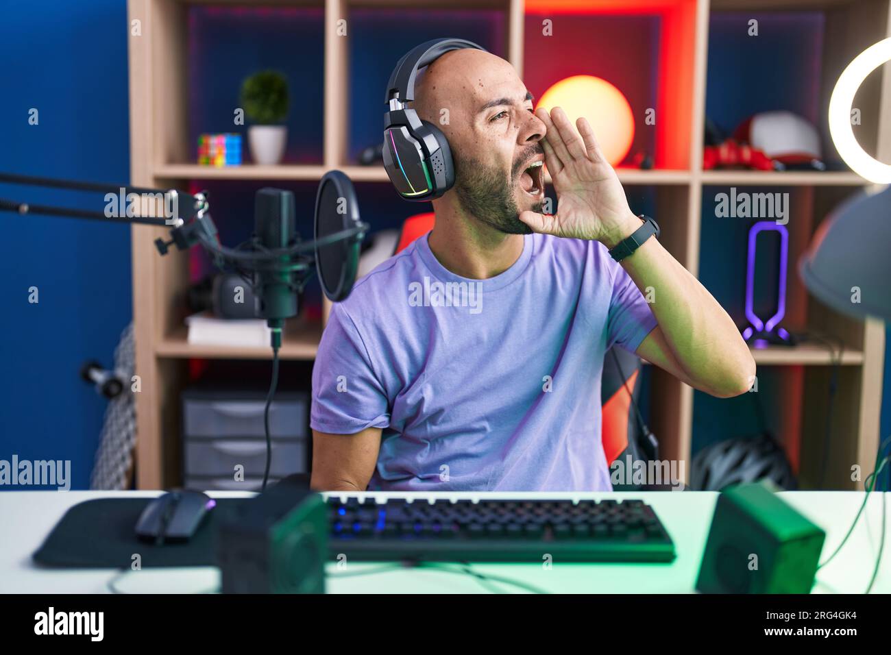 Middle age bald man playing video games wearing headphones clueless and ...