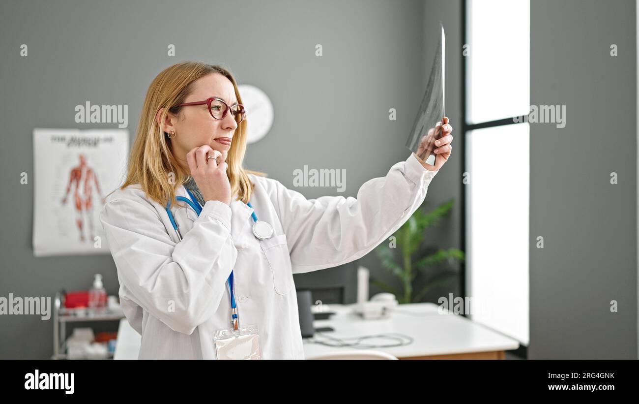 Young blonde woman doctor looking xray at clinic Stock Photo - Alamy