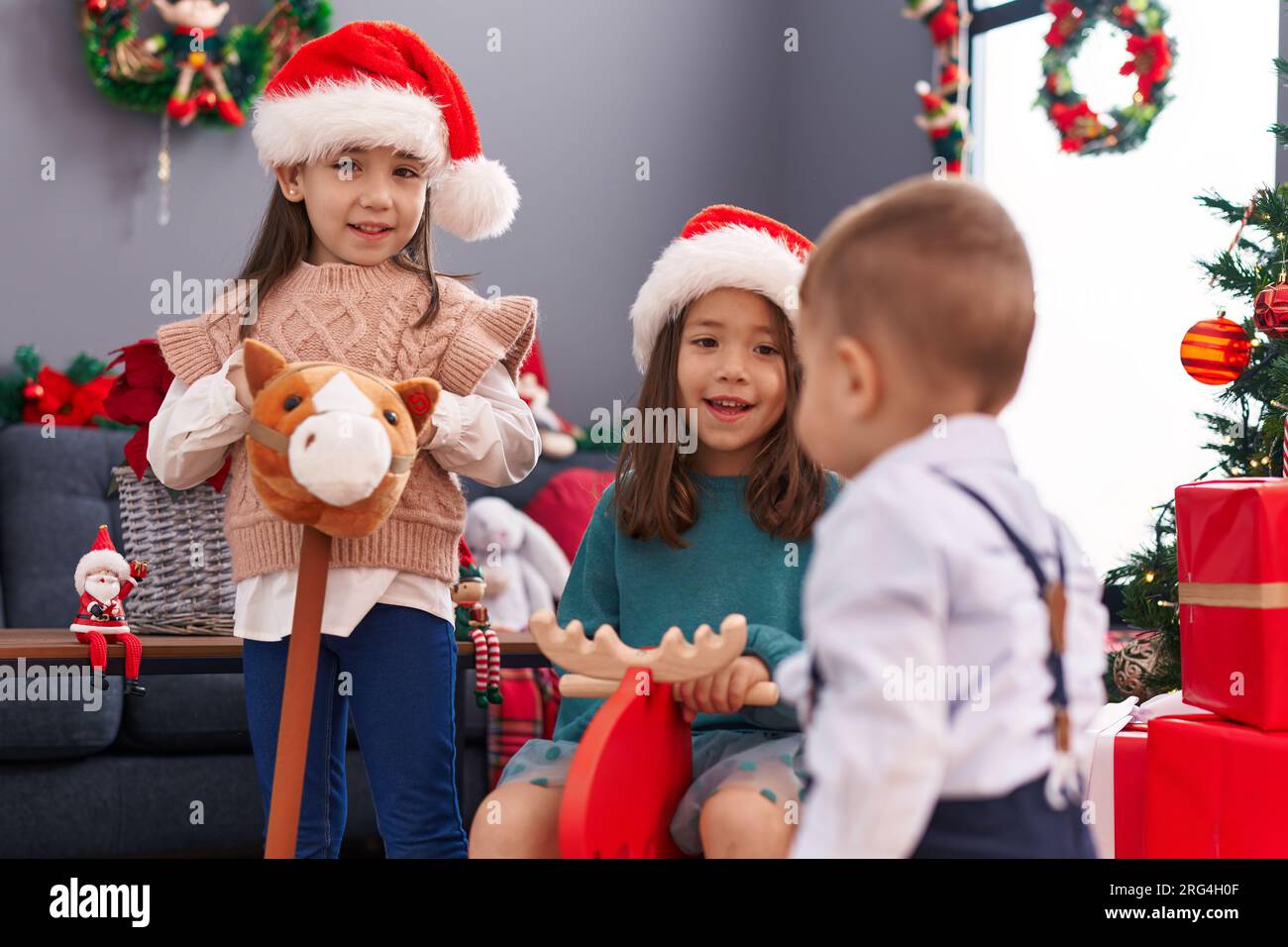 Group of kids playing with reindeer rocking and horse toy by christmas ...
