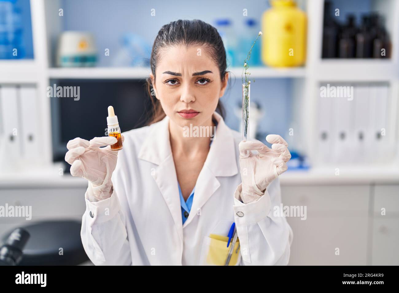 Young woman doing weed oil extraction at laboratory depressed and worry ...