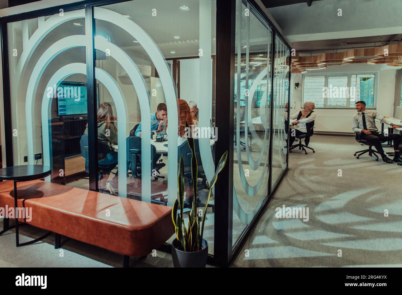 A group of young business entrepreneurs engages in a focused meeting ...