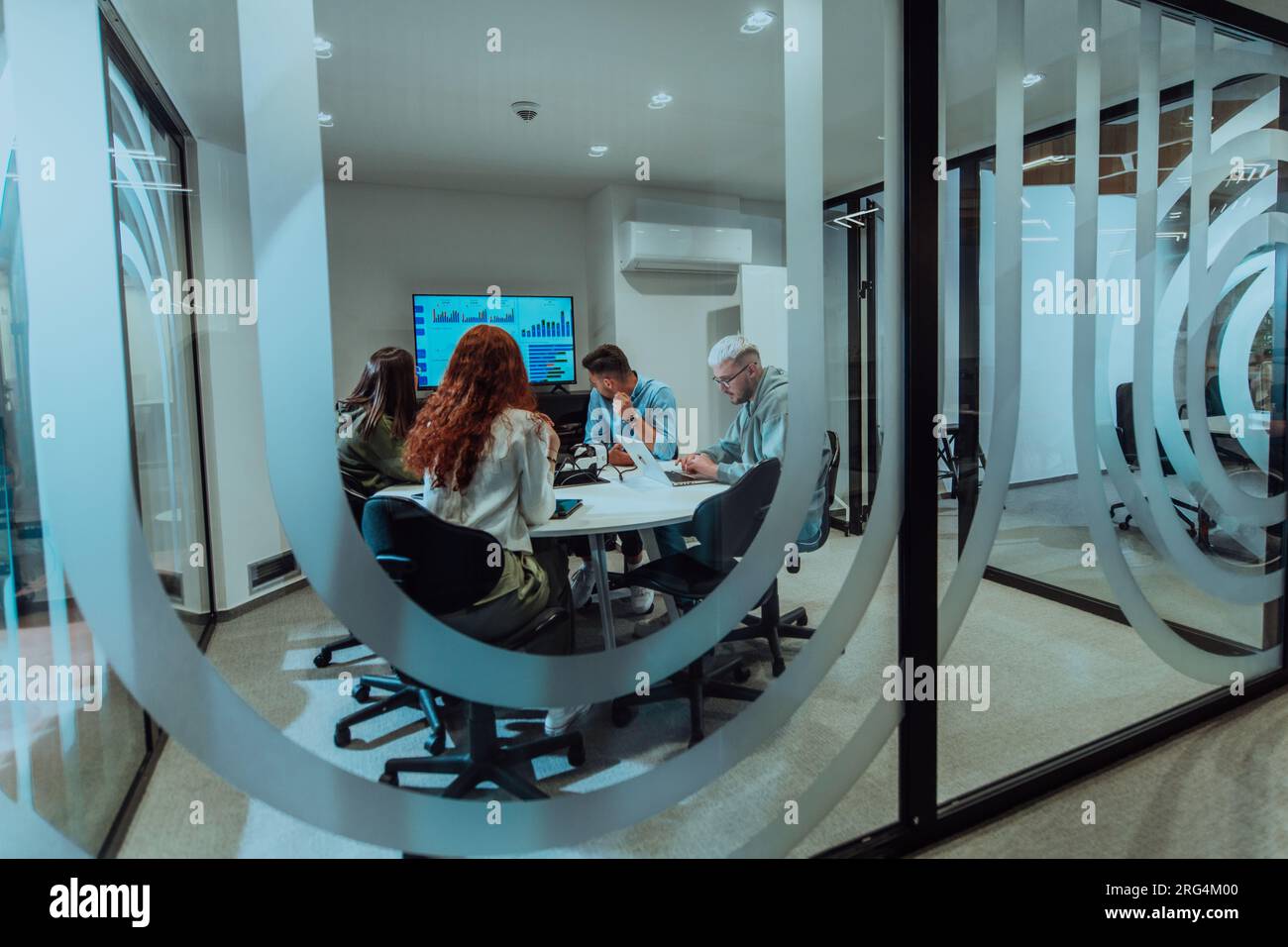 A group of young business entrepreneurs engages in a focused meeting ...