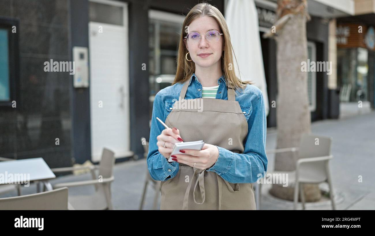 Young blonde woman waitress taking notes at coffee shop terrace Stock ...
