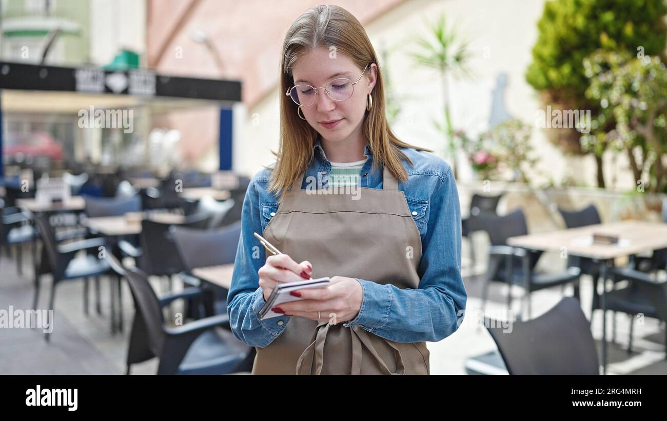 Young blonde woman waitress taking notes at coffee shop terrace Stock ...