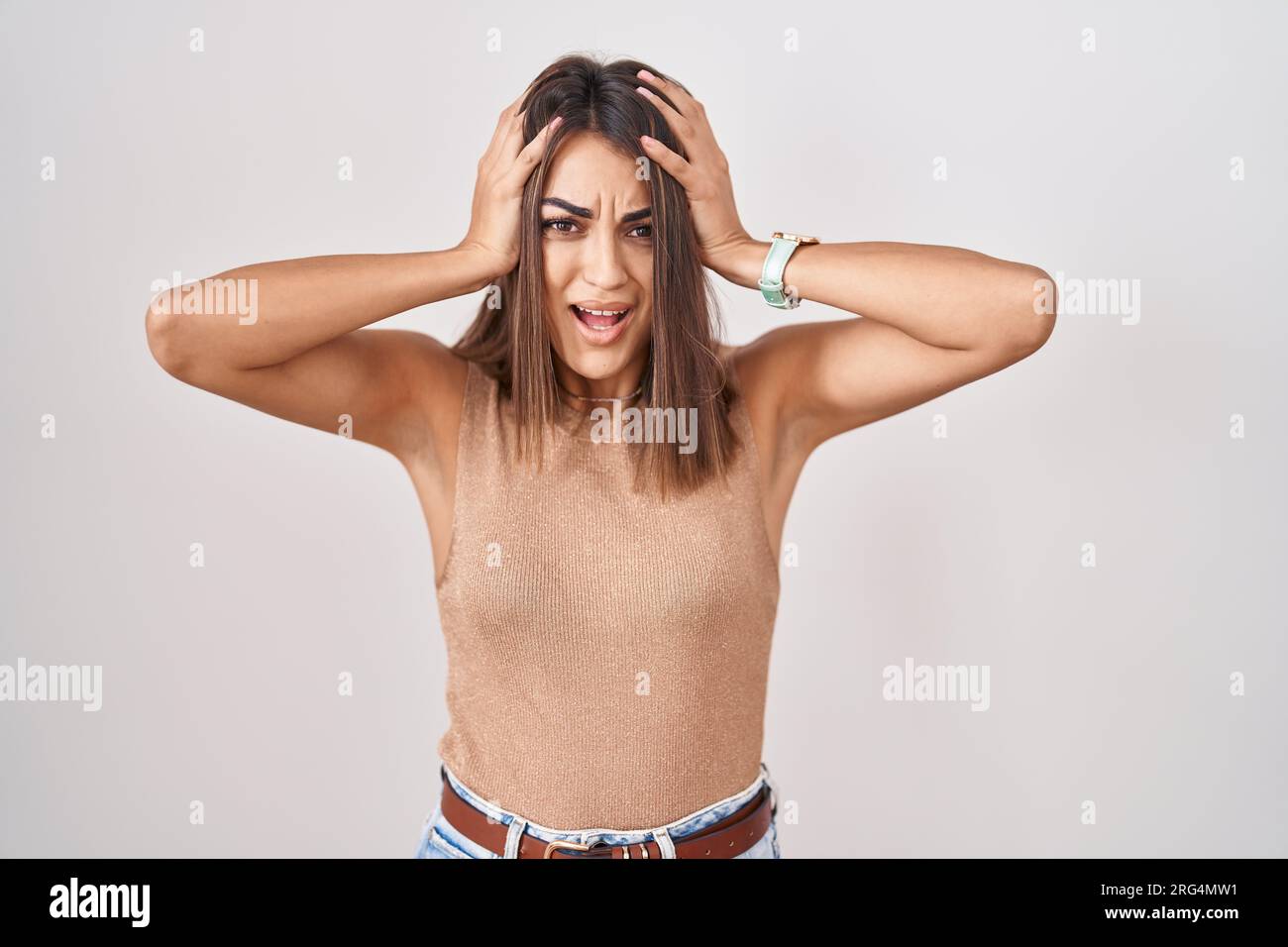 Young hispanic woman standing over white background crazy and scared ...