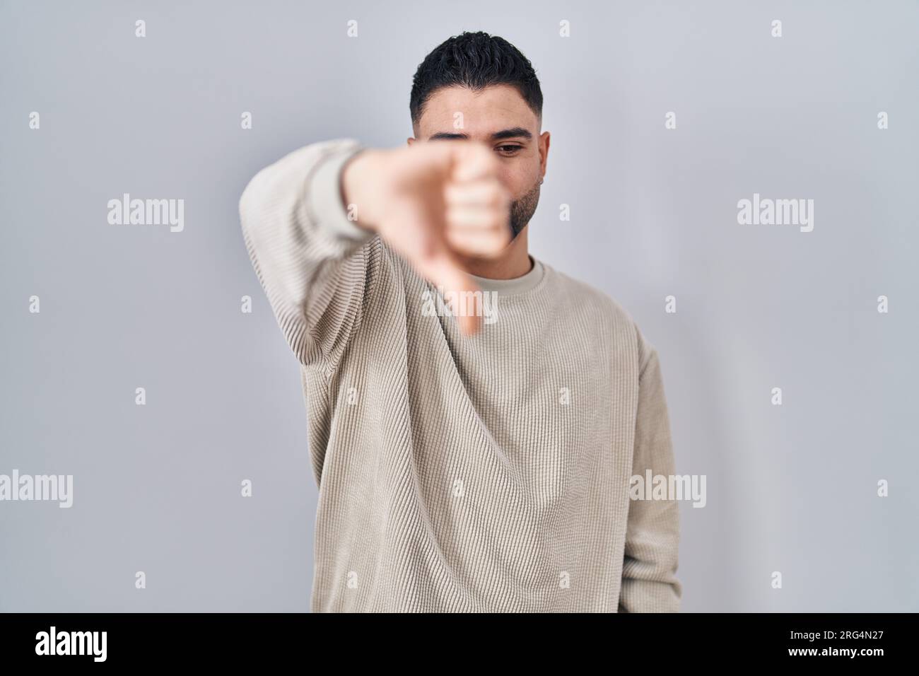 Young handsome man standing over isolated background looking unhappy ...