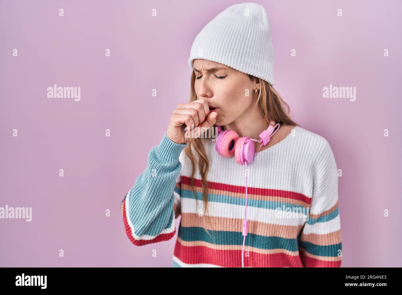 Young blonde woman standing over pink background feeling unwell and ...