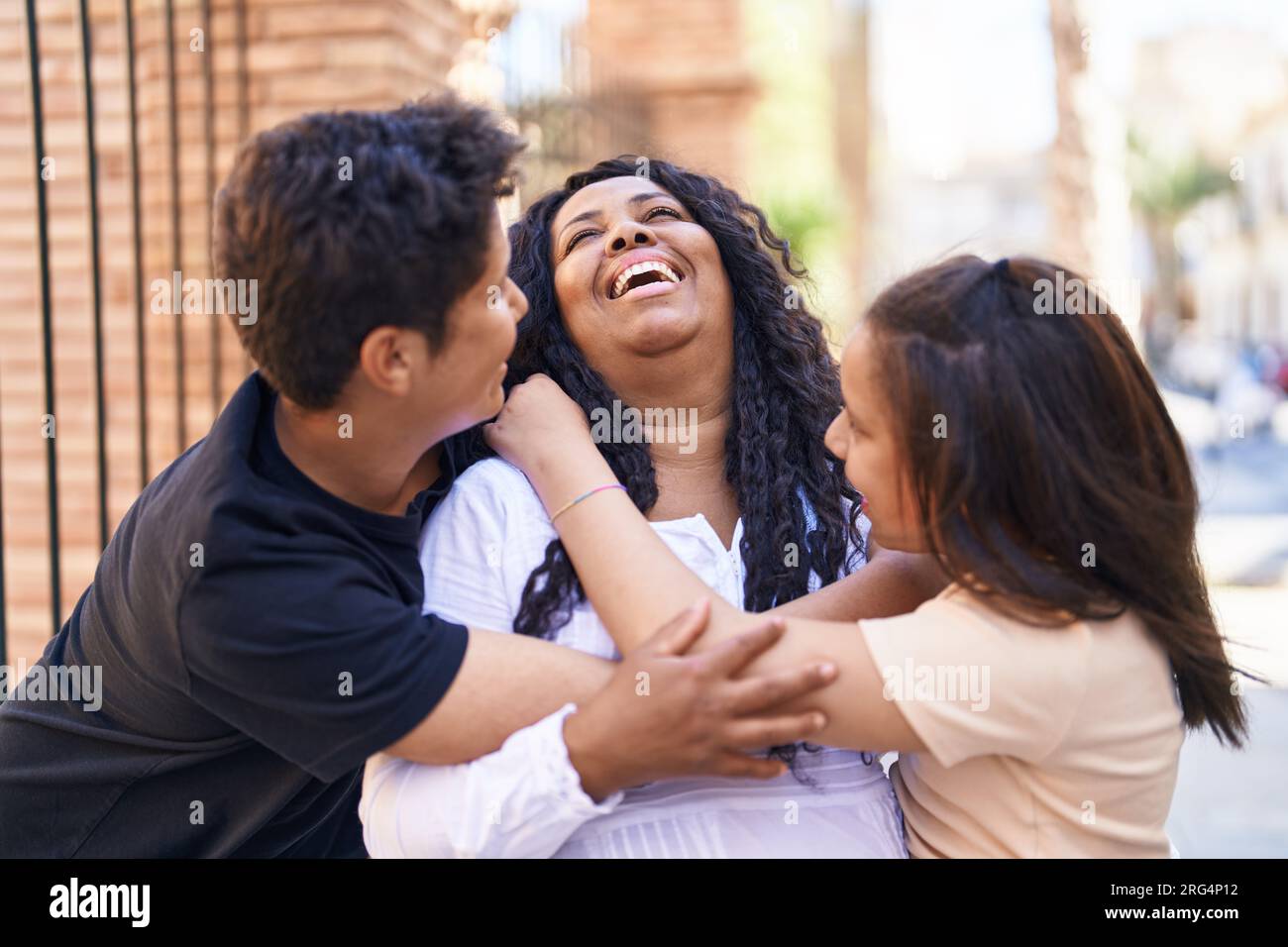 African american family hugging each other at street Stock Photo - Alamy