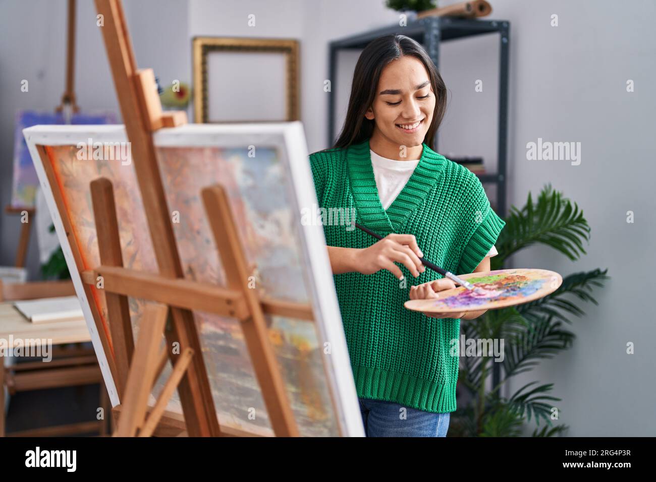 Young hispanic woman artist smiling confident drawing at art studio ...