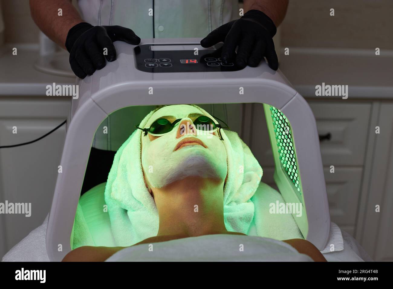 Woman getting facial treatment with led therapy Stock Photo - Alamy