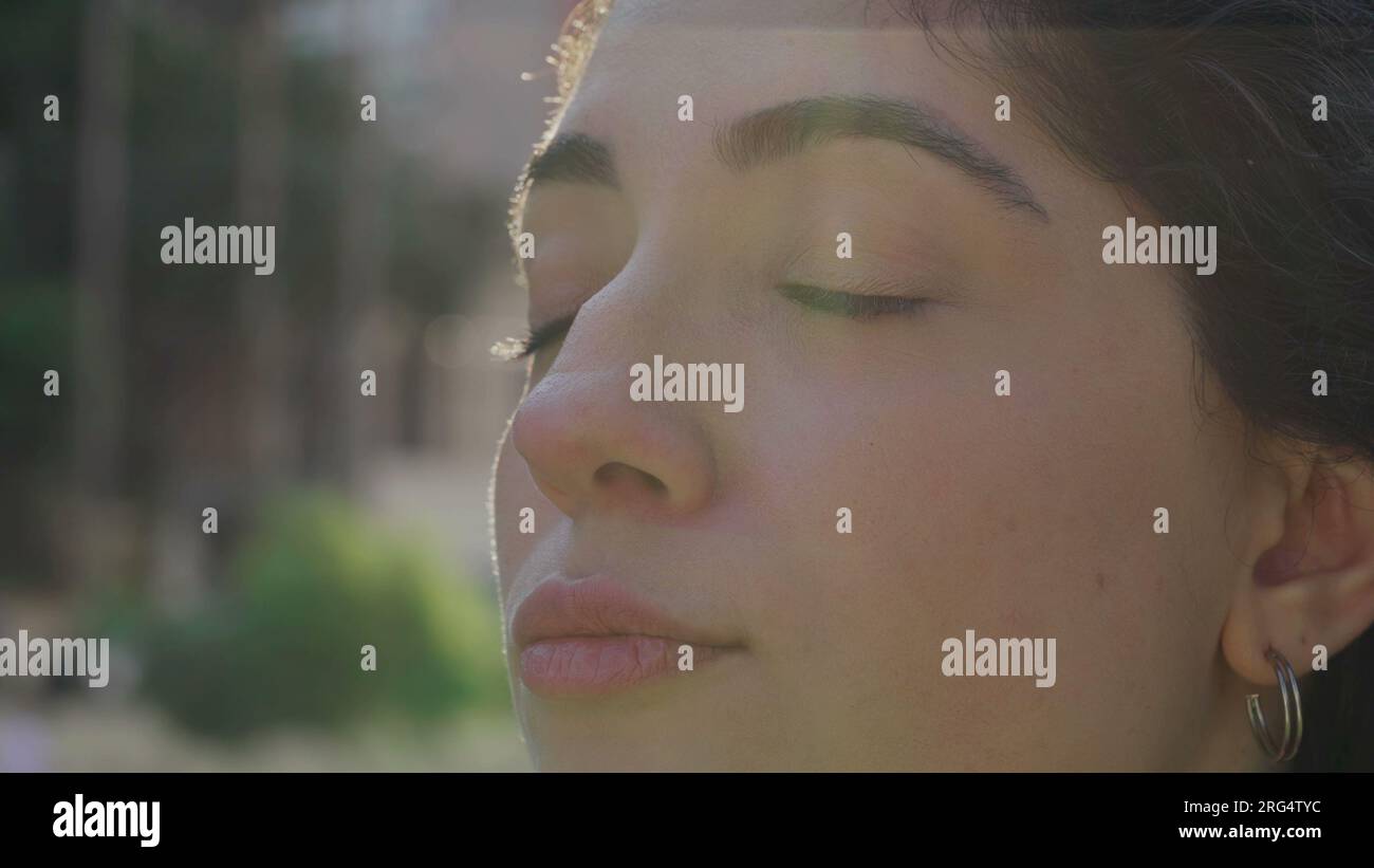 Meditative young woman closing eyes in mindfulness outside in nature ...