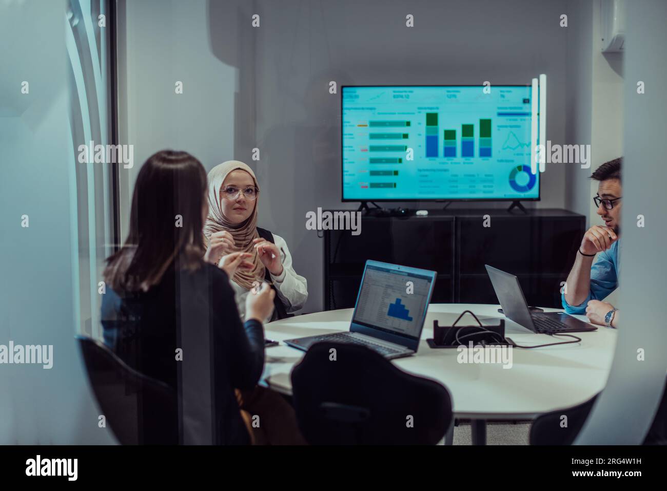 A group of young business entrepreneurs engages in a focused meeting ...