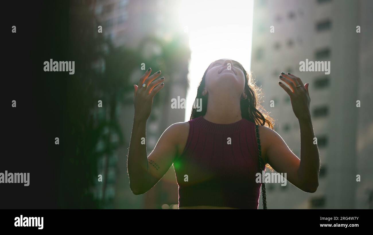 One Spiritual young woman standing outdoors looking up at sky feeling ...