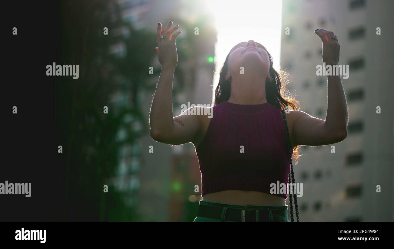 One Spiritual young woman standing outdoors looking up at sky feeling ...