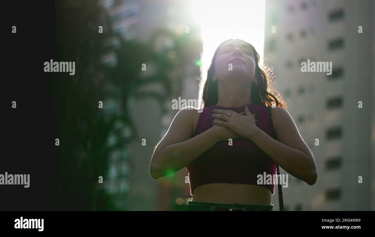 One Spiritual young woman standing outdoors looking up at sky feeling ...