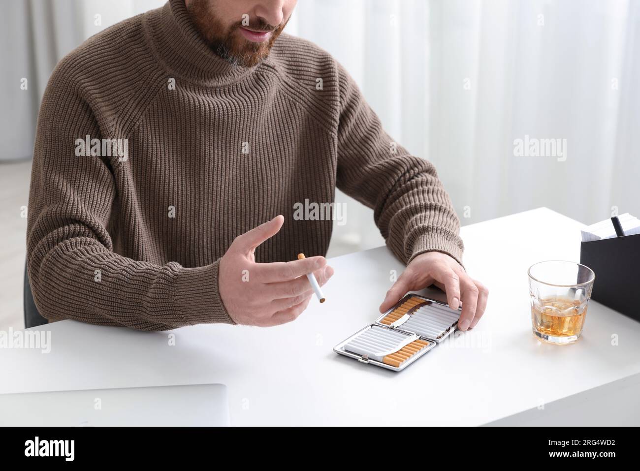 Man taking cigarette from case at white table in office, closeup Stock ...