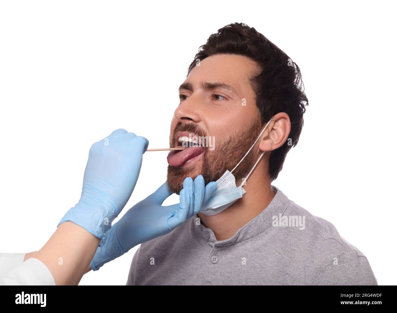 Doctor examining man`s oral cavity with tongue depressor on white ...