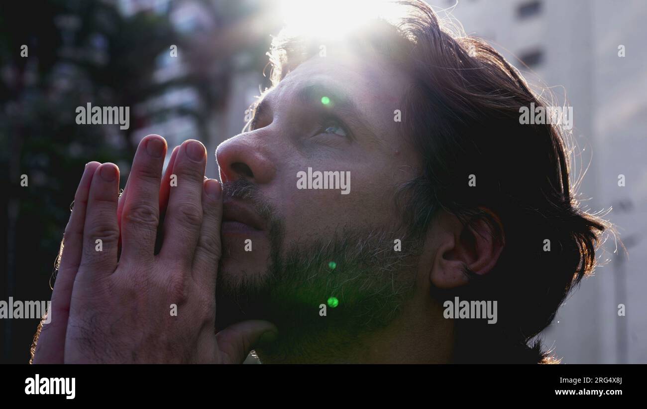 Faithful young man looking up at sky in prayer asking for God s help ...