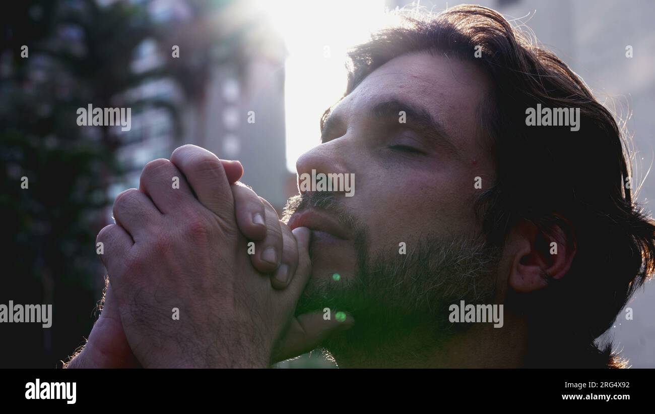 Faithful young man looking up at sky in prayer asking for God s help ...