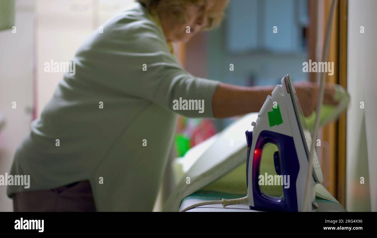 Ironing Out Domestic Chores Candid Footage of Senior Woman in Laundry ...