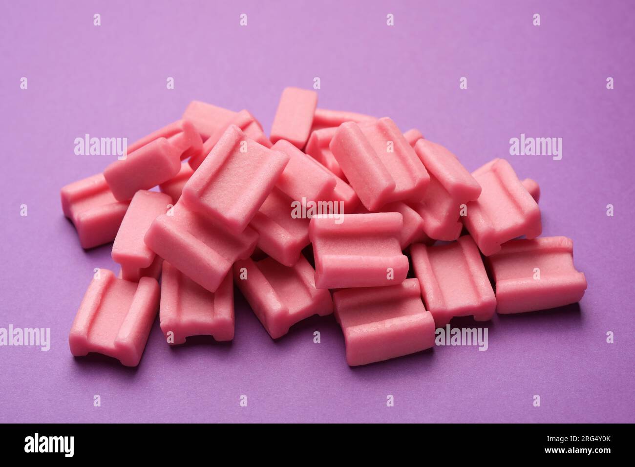 Tasty pink chewing gums on purple background, closeup Stock Photo - Alamy