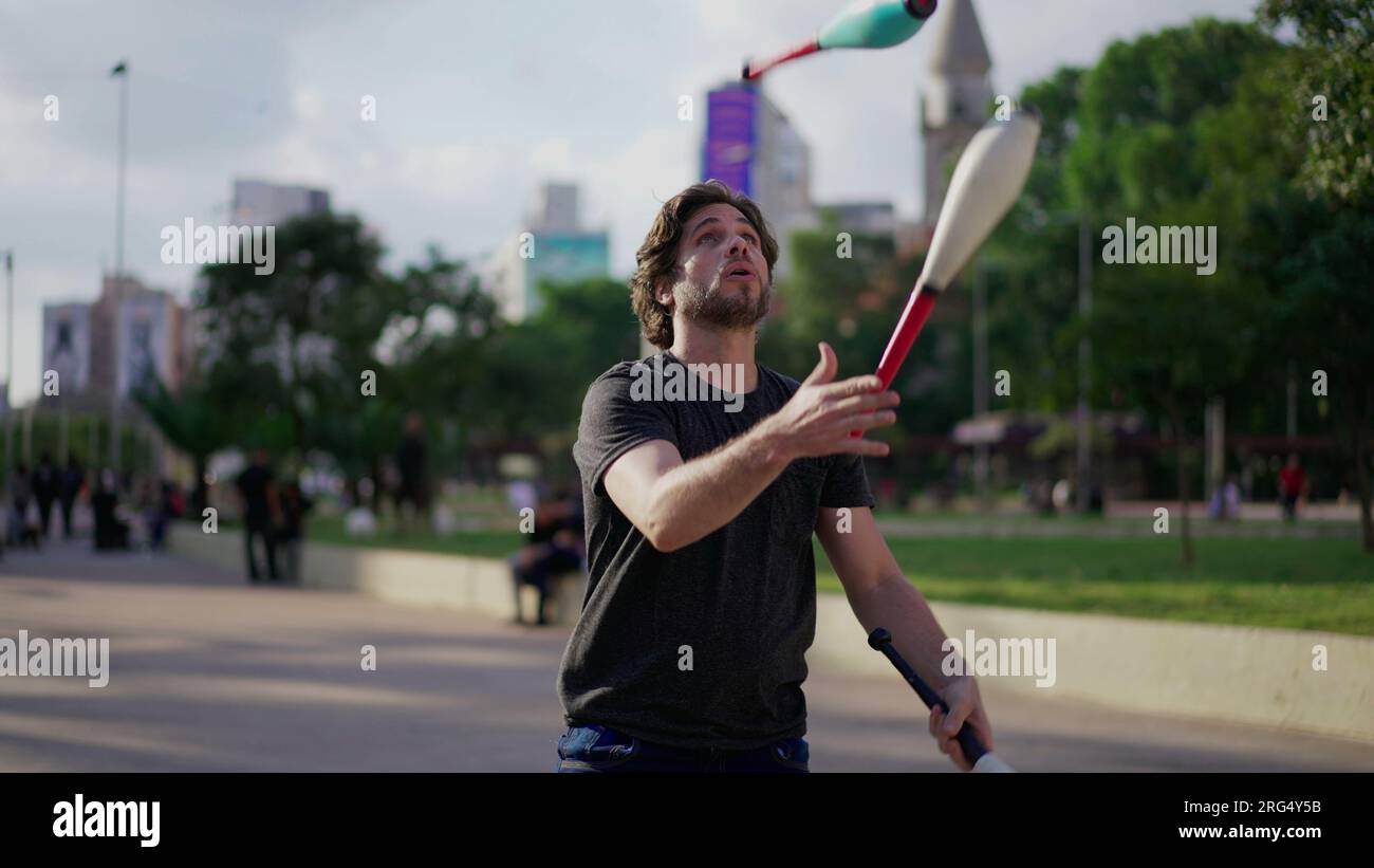 Male Juggler performer demonstrating his skills outside in urban city ...