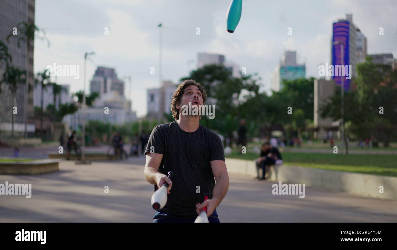 Male Juggler performer demonstrating his skills outside in urban city ...