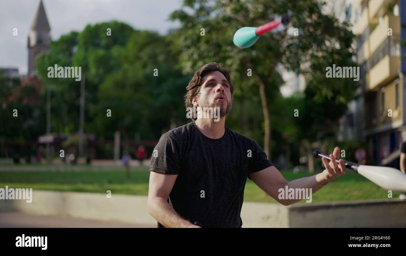 Male Juggler performer demonstrating his skills outside in urban city ...