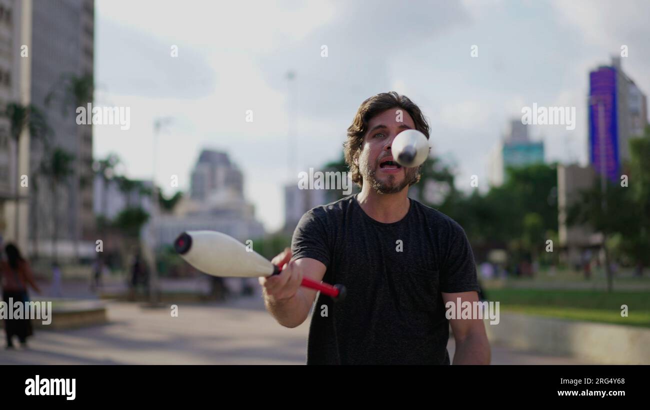 Male Juggler performer demonstrating his skills outside in urban city ...
