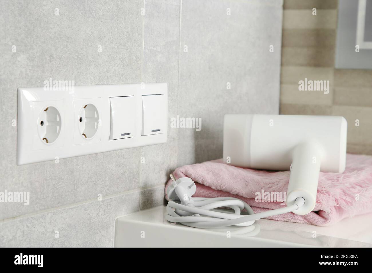 Power sockets, light switches on wall near table with hairdryer and ...
