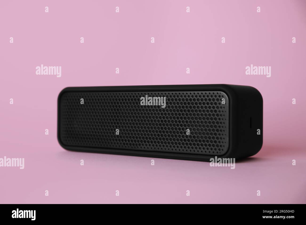 One portable bluetooth speaker on pink background. Audio equipment ...