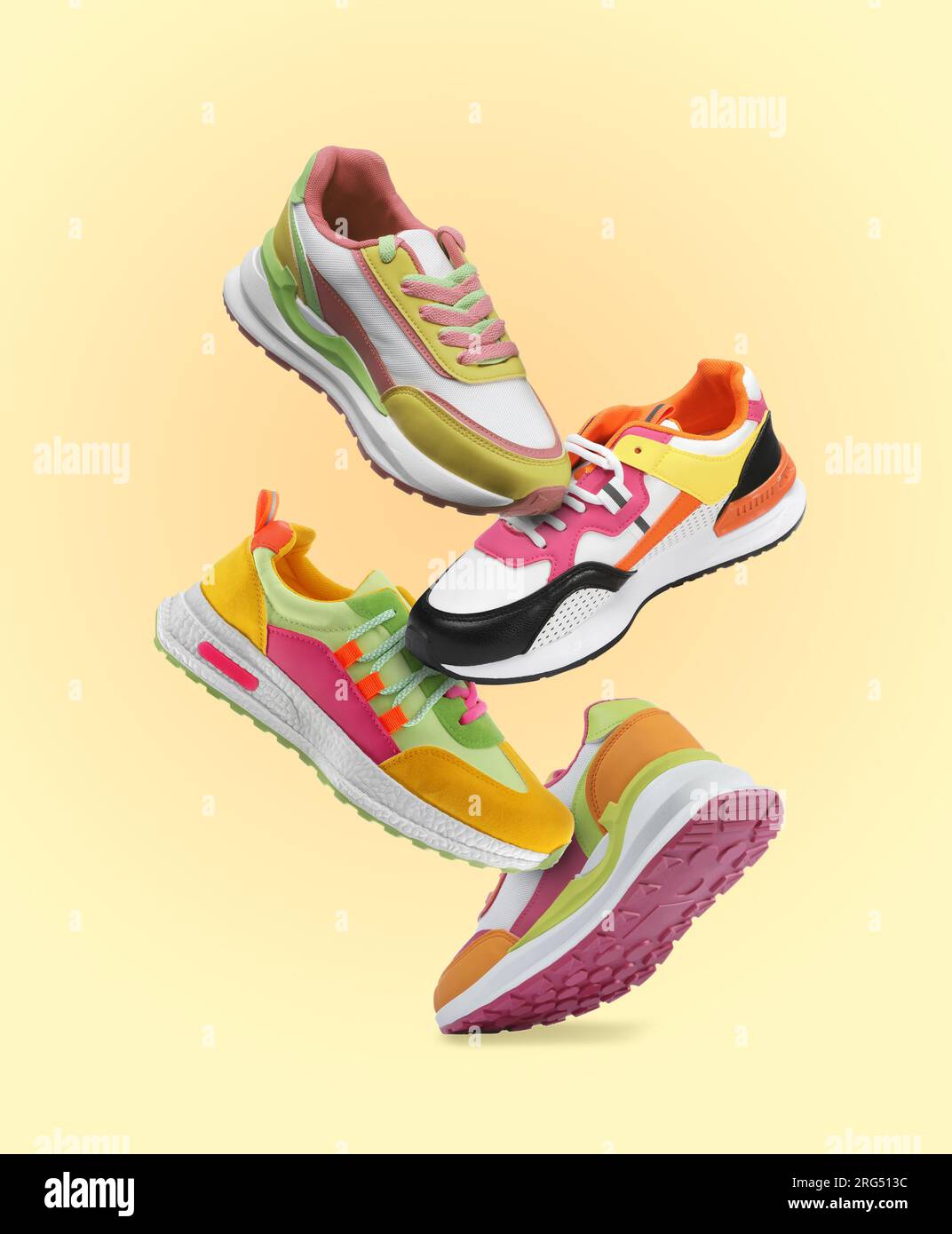 Different sneakers falling on beige gradient background Stock Photo - Alamy