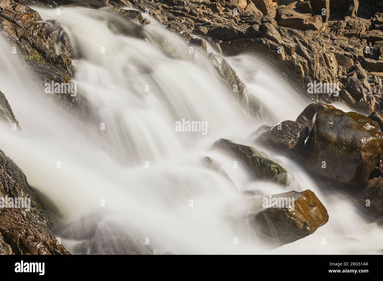Water pouring over a waterfall in sunshine, at Welcombe Mouth, Hartland ...
